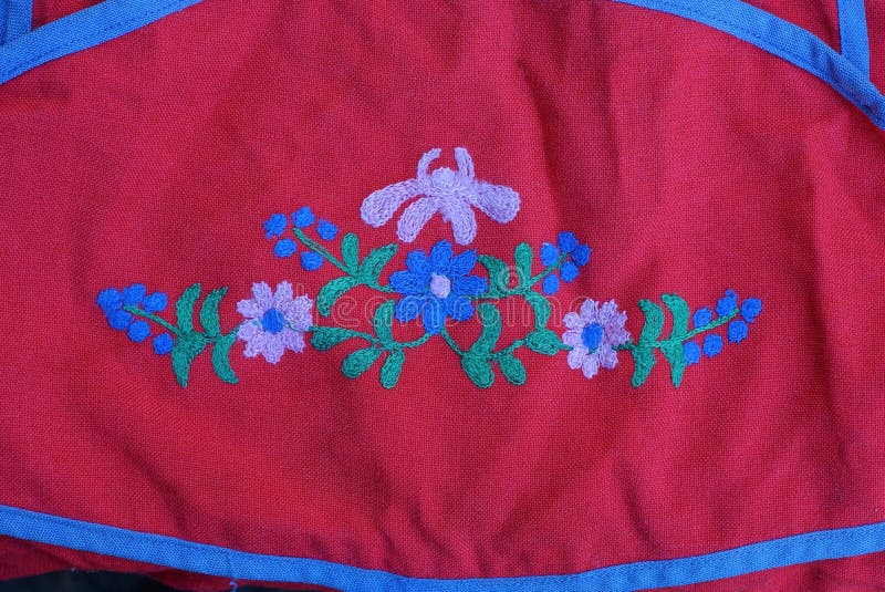A Patch of Embroidered Colored Flower Patterns on Red Fabric Stock ...