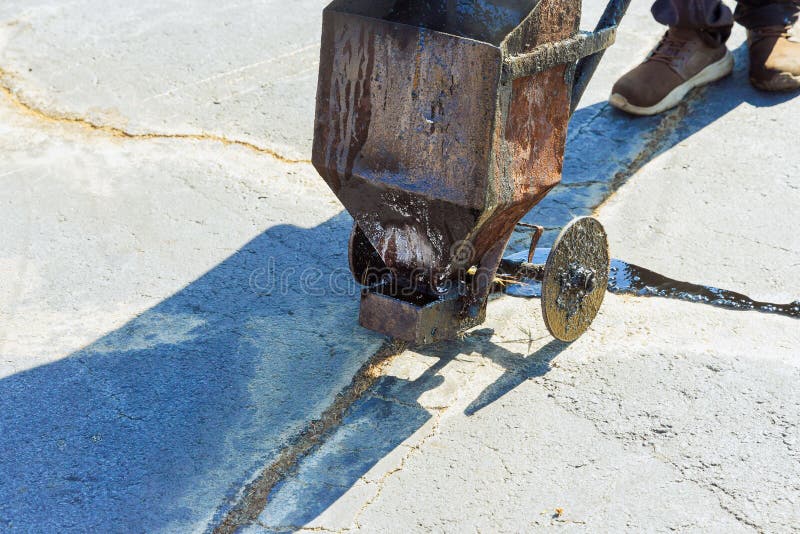 Patcher Performs Work that Involves Coating Asphalt Cracks, Sealing ...
