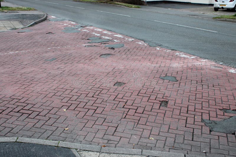 Patchy UK Junction Paved with Red Bricks and Various Potholes Filled ...
