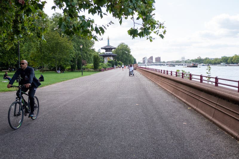 A Paved Path Along the River Thames in London, Features a Man Cycling ...