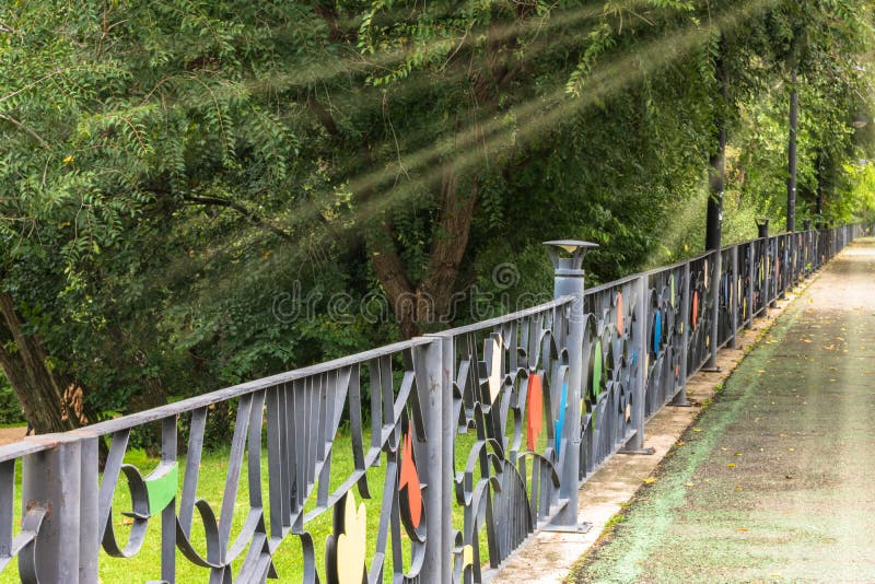 Path in the Park with Colorful Metal Railing and Sun Rays Stock Photo ...