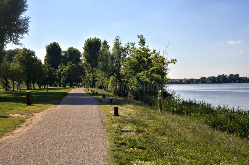 Path with People Walking by the Shore of a Lake on a Clear Day Stock ...