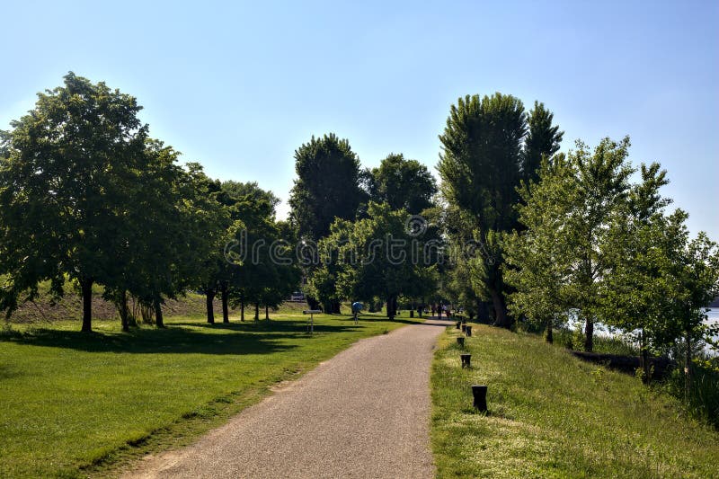 Path with People Walking by the Shore of a Lake on a Clear Day Stock ...