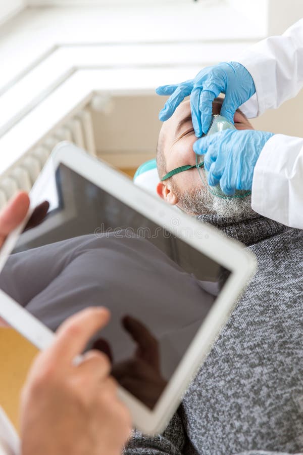 Patient in Anesthesia with Oxygen Mask, Doctor with Tablet Stock Image ...