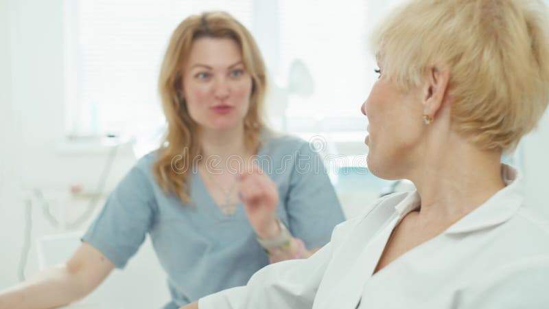 Between Patient Appointments, Two Doctors Communicate with Each Other ...