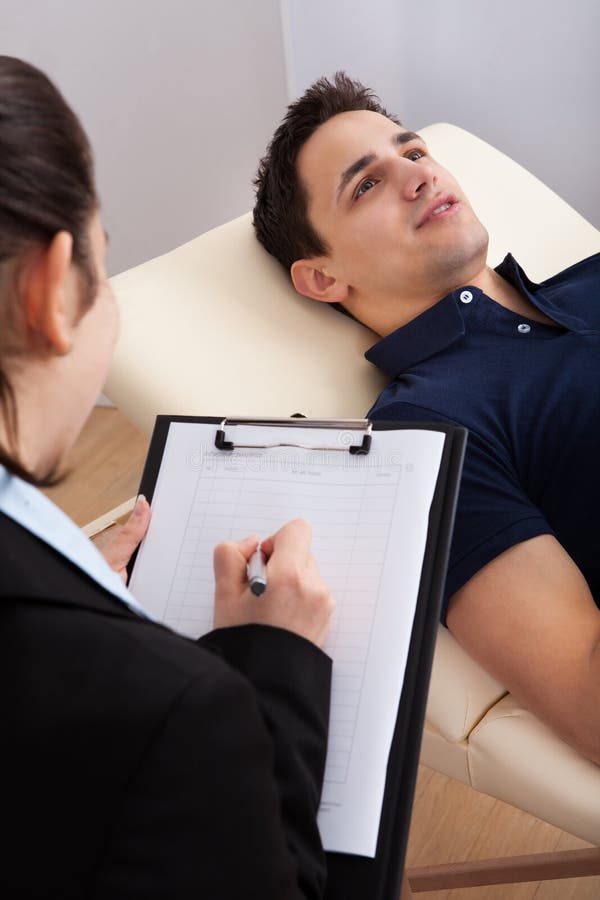 Patient Communicating while Psychologist Writing Notes Stock Photo ...