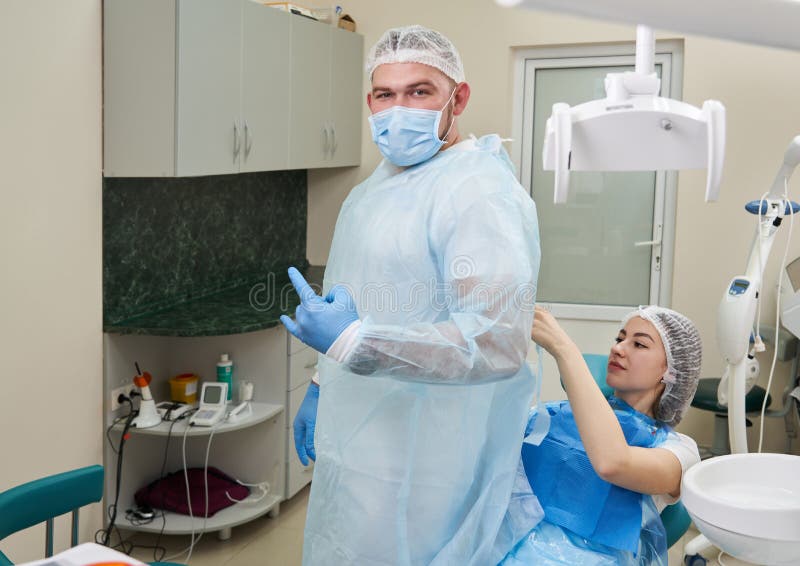 Patient Helping Dentist To Put on Uniform in Dental Office Stock Image ...