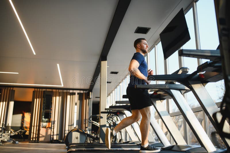 Determined Man Running on Treadmill during Rehabilitation in Modern Gym ...