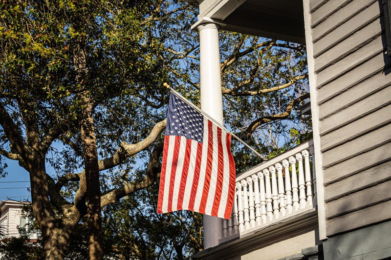 A Patriotic Display of an American Flag Hanging on the Side of a Home ...