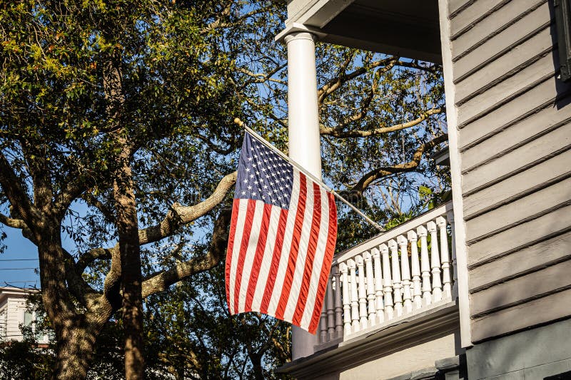 A Patriotic Display of an American Flag Hanging on the Side of a Home ...