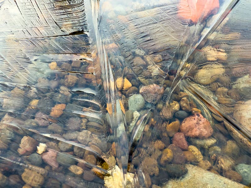 Pattern in Ice of Frozen Water Above Layer of Pebbles in Multiple ...
