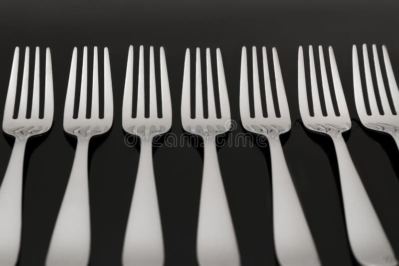 Pattern with Many Silver Forks on Black Mirror Background. Concept ...