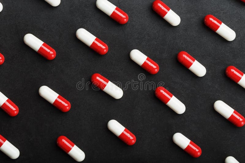 A Pattern of Red and White Pill Capsules on a Black Background ...
