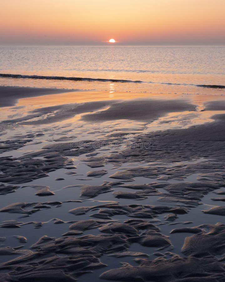 Pattern in Sand and Colorful Reflection of Setting Sun in Water Stock ...