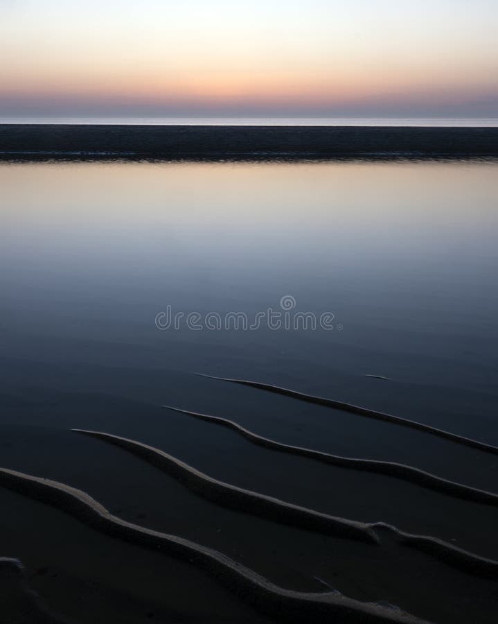 Pattern in Sand and Colorful Reflection of Setting Sun in Water Stock ...