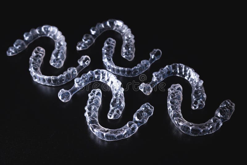 Pattern of Transparent Aligners, Invisible Braces Lies on a Black ...