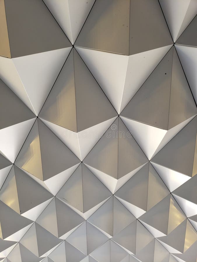 The Pattern on the Wall Features Interlocking Grey Triangles, Some with ...
