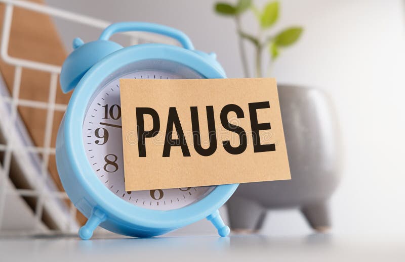 Pause Text on on a Sticker Pasted on an Alarm Clock on the Office Desk ...