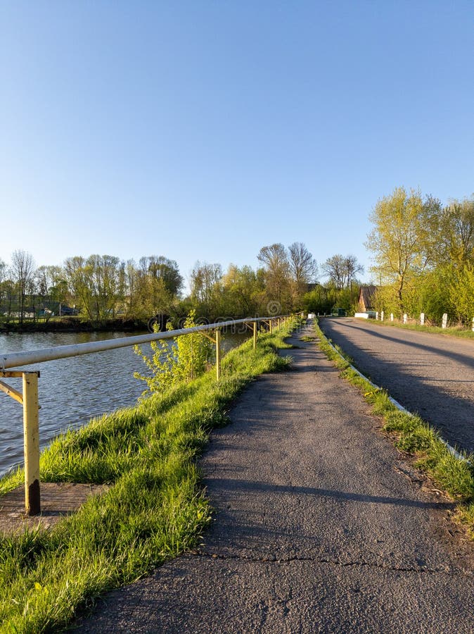 A Paved Path Next To a Body of Water Stock Photo - Image of calm, river ...