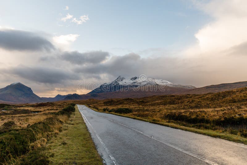 Paved Road Winding through a Dry Grass-covered Landscape with a ...