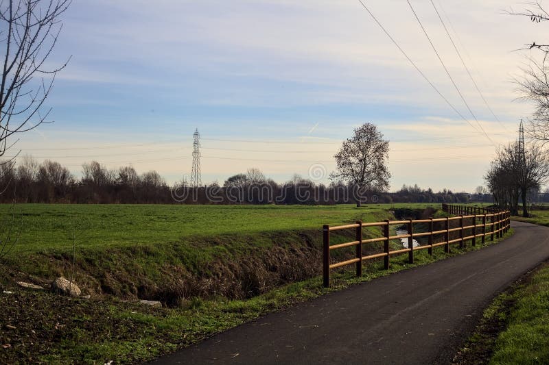 Paved Trail Bordered by a Railing and a Stream of Water between Fields ...