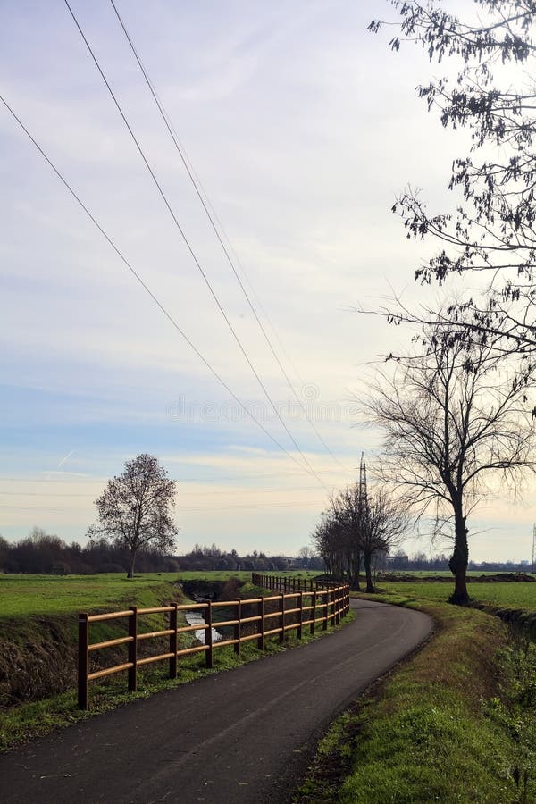 Paved Trail Bordered by a Railing and a Stream of Water between Fields ...