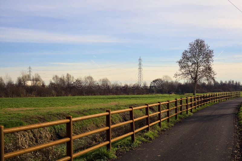 Paved Trail Bordered by a Railing and a Stream of Water between Fields ...