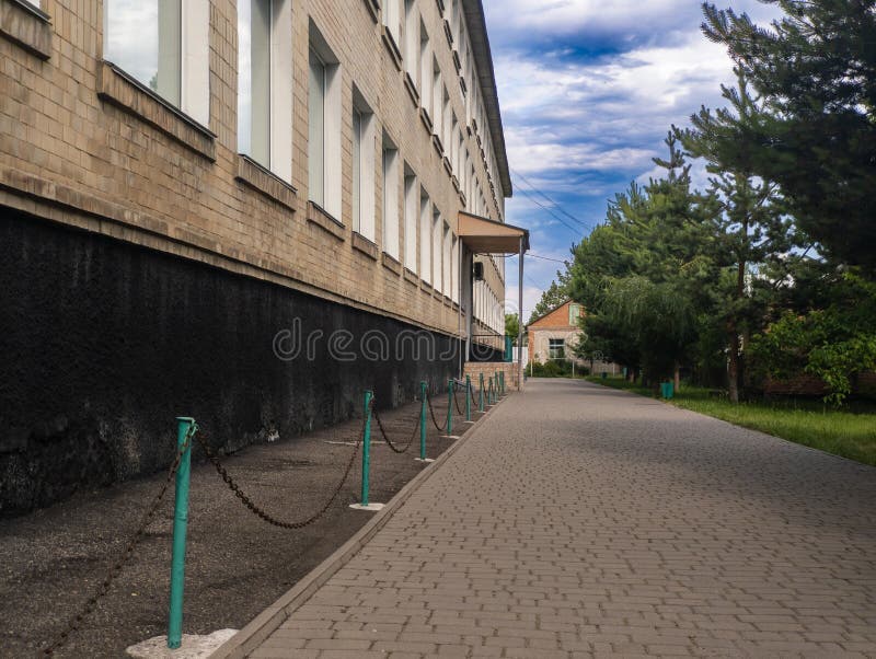 Paving Path with Green Pillars in Front of a Brick Building Stock Image ...