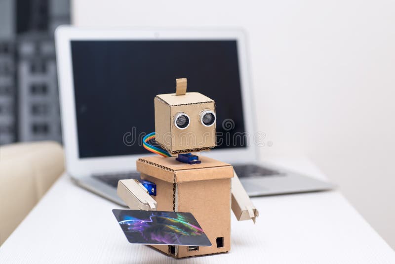 Payment by Card on Line. Robot Holding a Credit Card Stock Photo ...