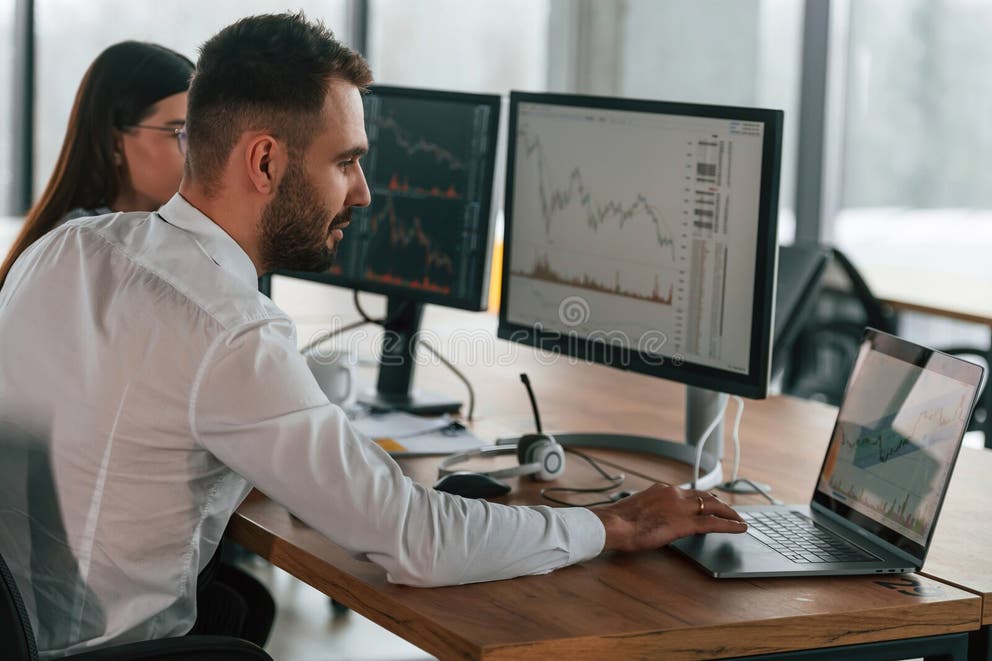 By the Pc Monitors. Two Employees are Working in the Office Together ...