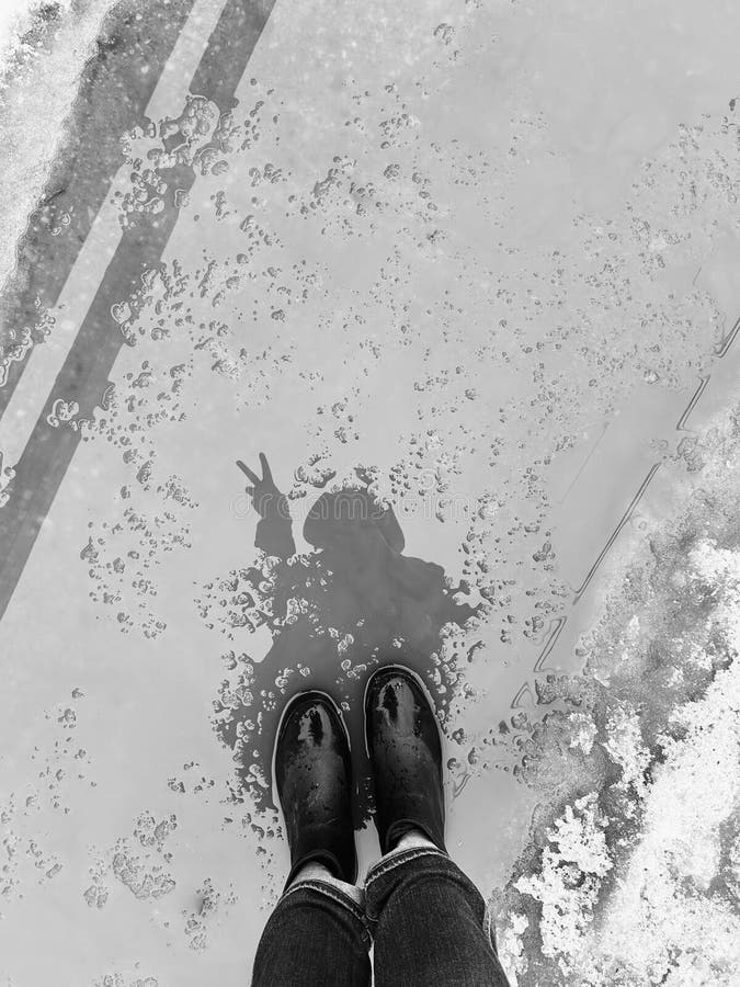 A Puddle Reflects the Image of a Person S Hand Making a Peace Sign ...