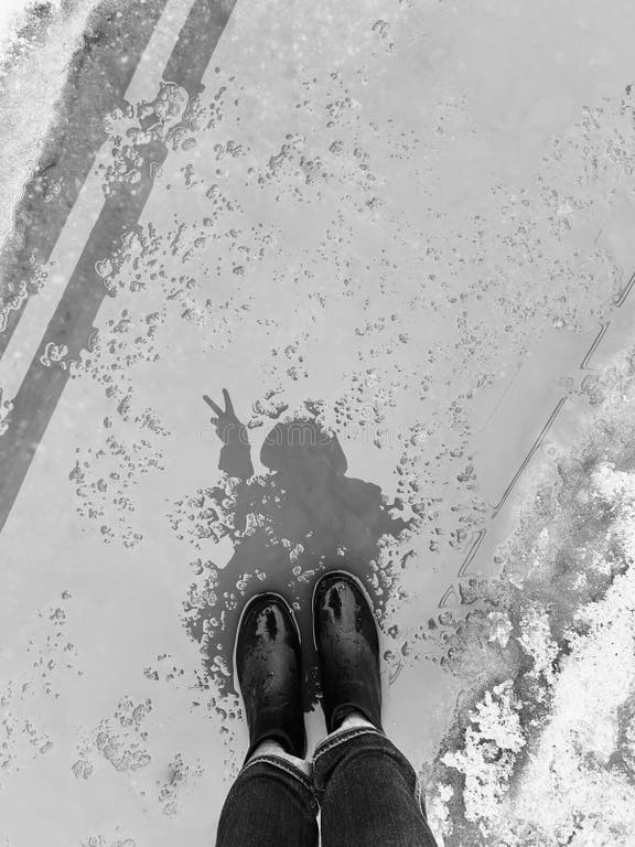 A Puddle Reflects the Image of a Person S Hand Making a Peace Sign ...