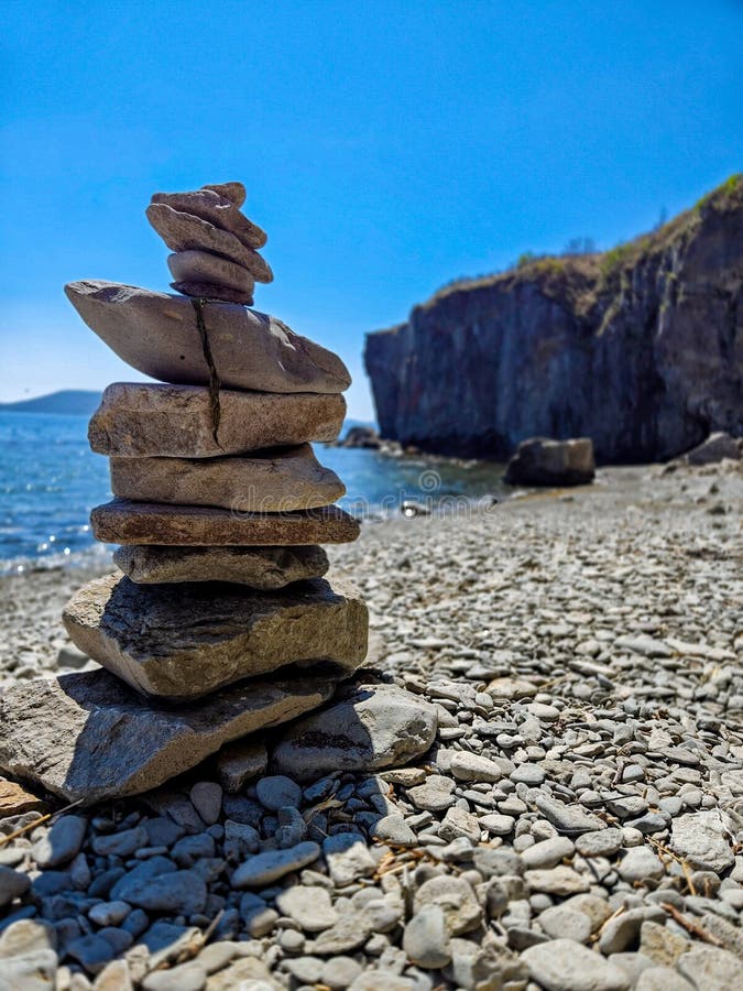 Stacked Rocks on a Serene Pebble Beach with Blue Sky Stock Image ...