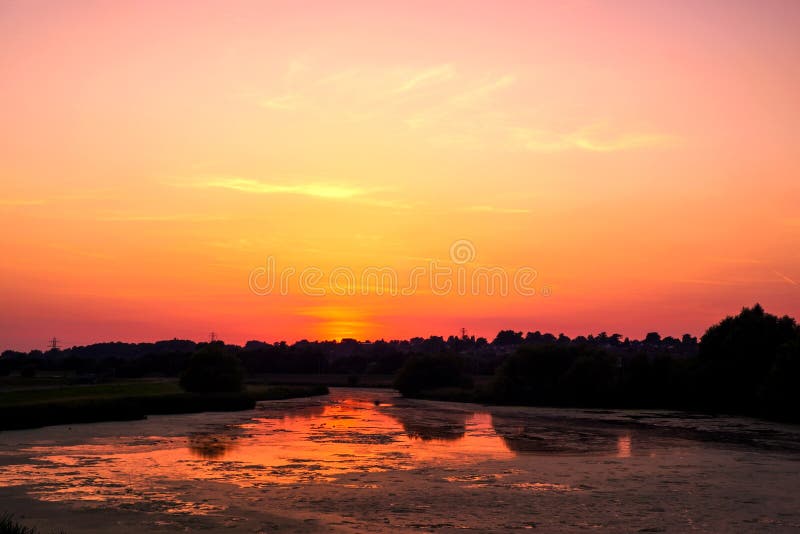 Peaceful Lake at Sunset with Calm Water and Dramatic Sky Stock Image ...