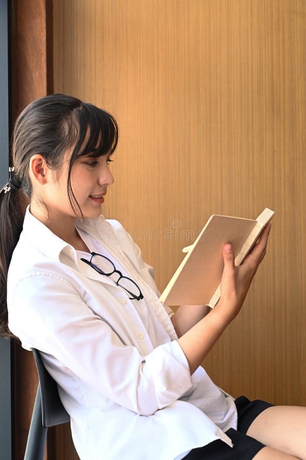 Peaceful Young Woman Reading Book in Library. Stock Image - Image of ...