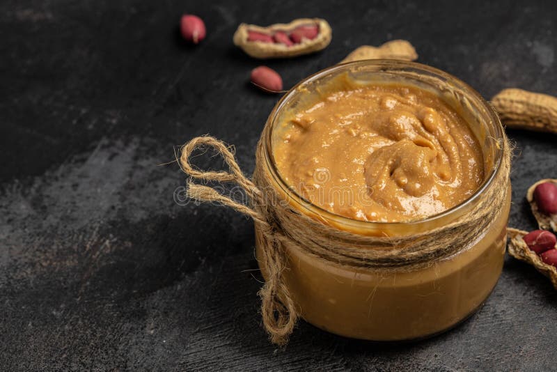 Peanut Butter or Paste in an Open Jar and Peanuts in the Peel Scattered ...