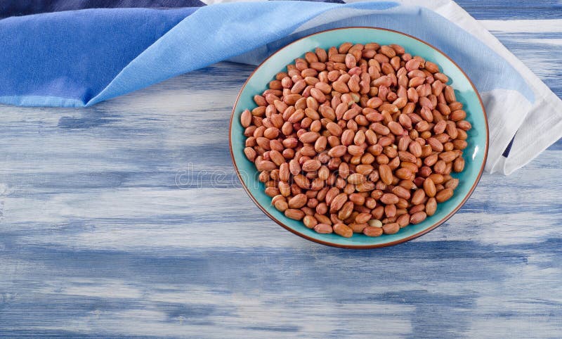 Peanuts on a blue plate . stock image. Image of healthy - 56759739