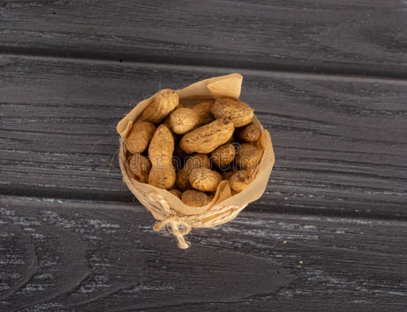 Peanuts in Craft Paper on a Dark Background Stock Photo - Image of ...