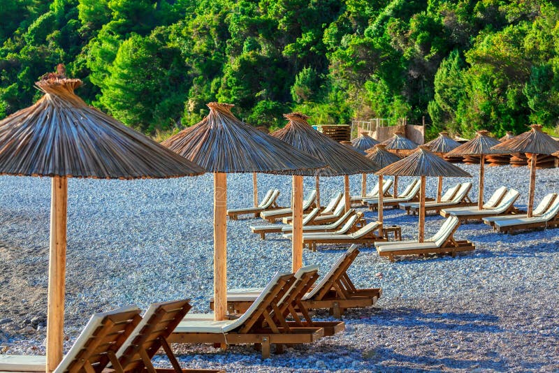 Pebble Beach with Sun Umbrellas Stock Photo - Image of lounger ...