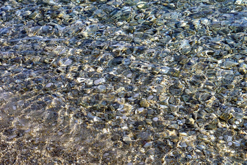 Pebble Beach Under Sea Water with Sun Rays Reflecting on the Waves ...