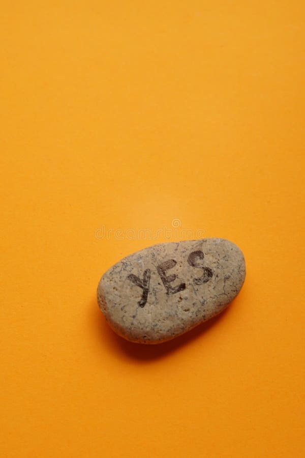 Pebble Stone with Text Yes on it. Orange Background Stock Photo - Image ...