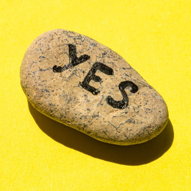 Pebble Stone with the Text Yes on Yellow Table Stock Image - Image of ...