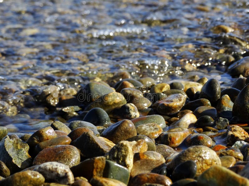 Pebbles on the river Bank stock photo. Image of water - 129673748