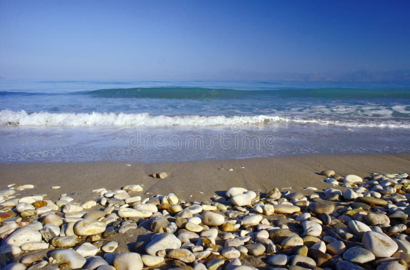 Pebbles on a sandy beach stock image. Image of clouds - 46199981
