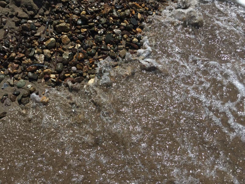 Pebbles on a sandy beach stock photo. Image of outdoors - 80843208