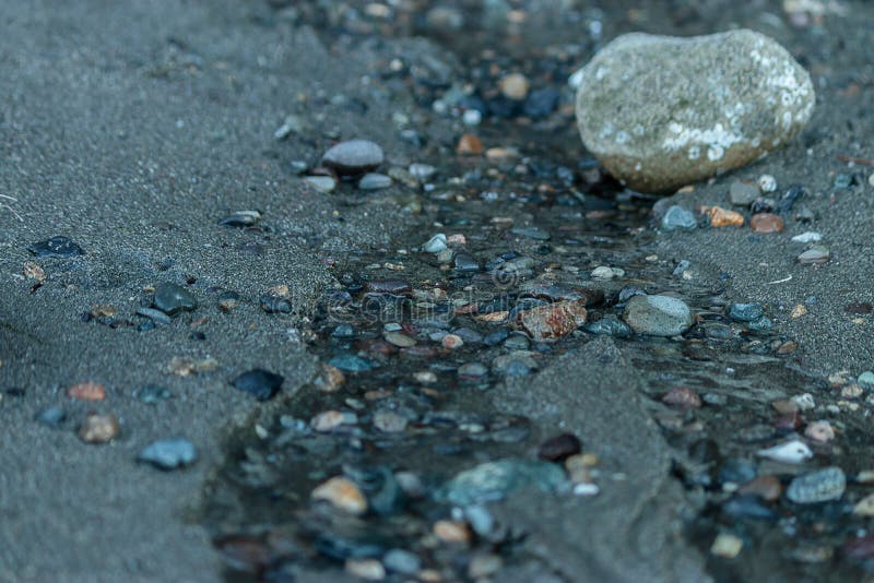 Pebbles in a Trickle of Water on a Beach Stock Photo - Image of sand ...