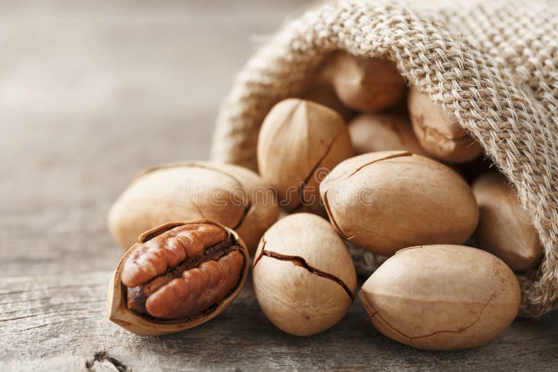 Pecans Spill Out of a Bag on a Wooden Table, Close-up. Peeled, in a ...