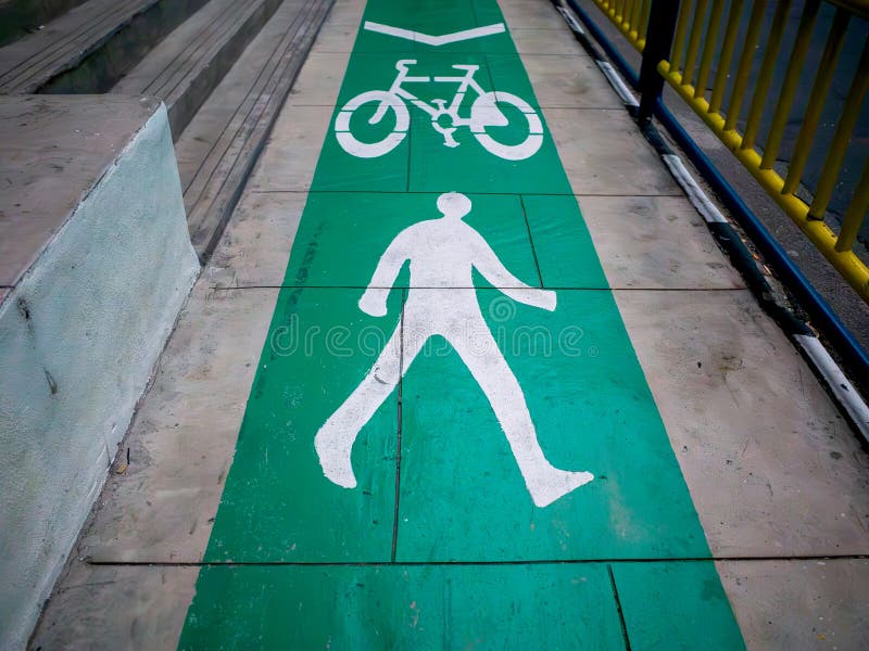 Pedestrian and Bicycle Path Symbol Painted on a Green Walkway Stock ...