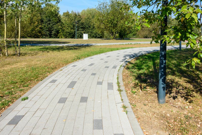 A Pedestrian Path Made of Paving Slabs Against the Backdrop of a Well ...