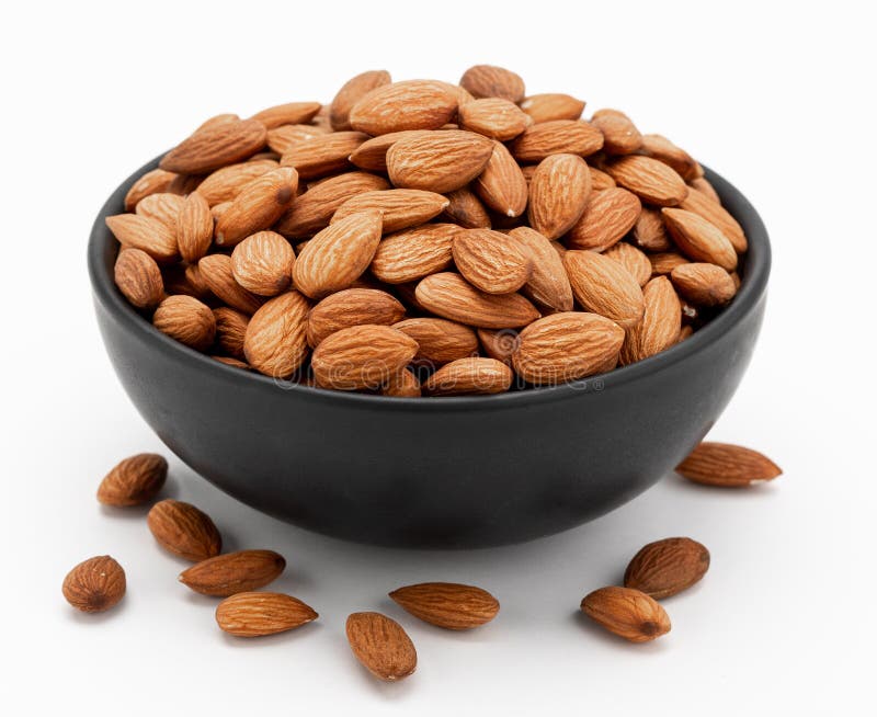Peeled Almonds in a Bowl and a Few Nuts Scattered Around on a White ...